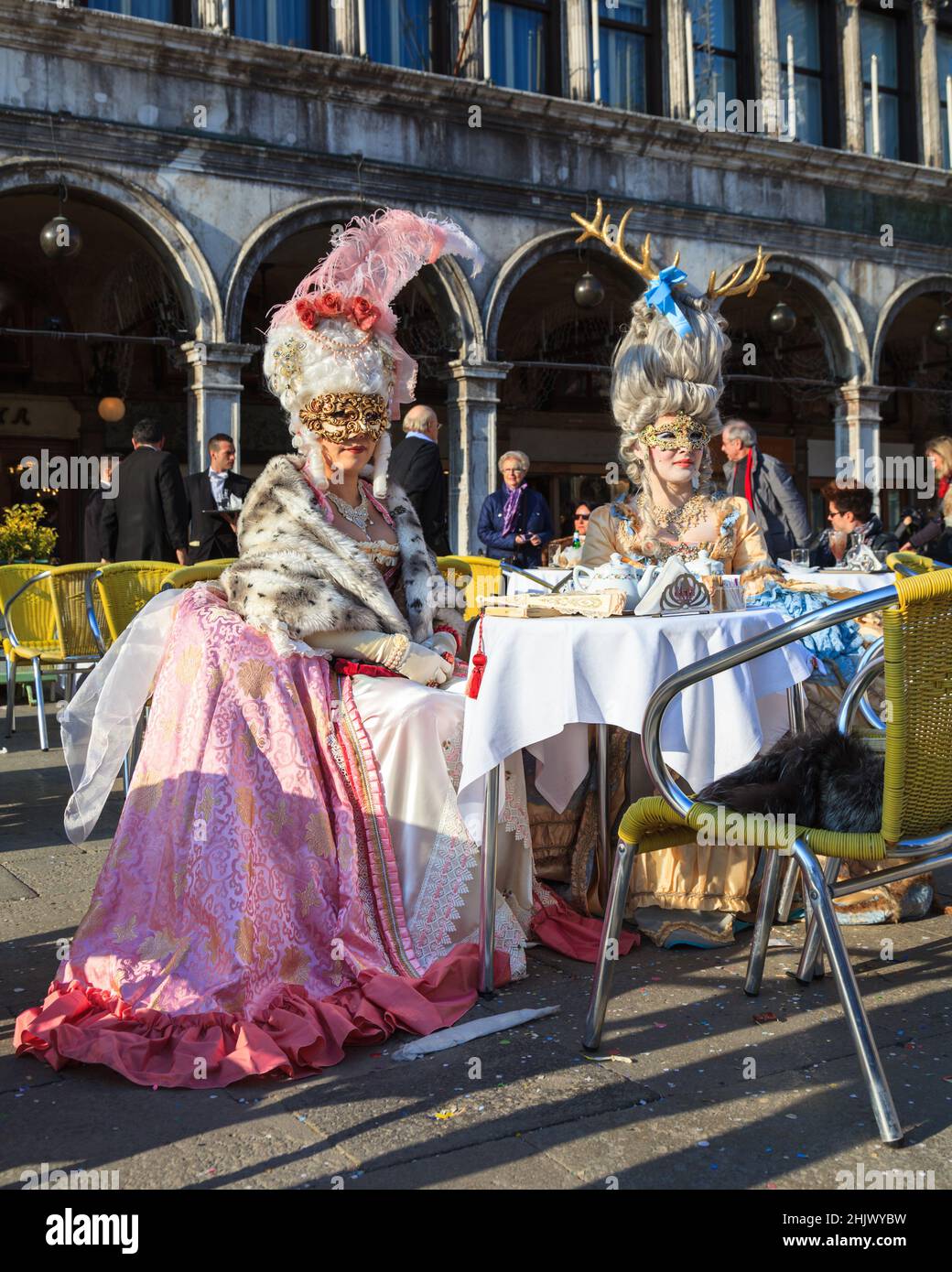 Women in historic rococo Venetian fancy dress costume and wig siting in ...