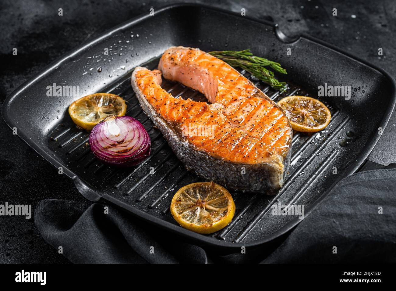 Salmon Fish Steak grilled on a grill pan with herbs. Black background ...