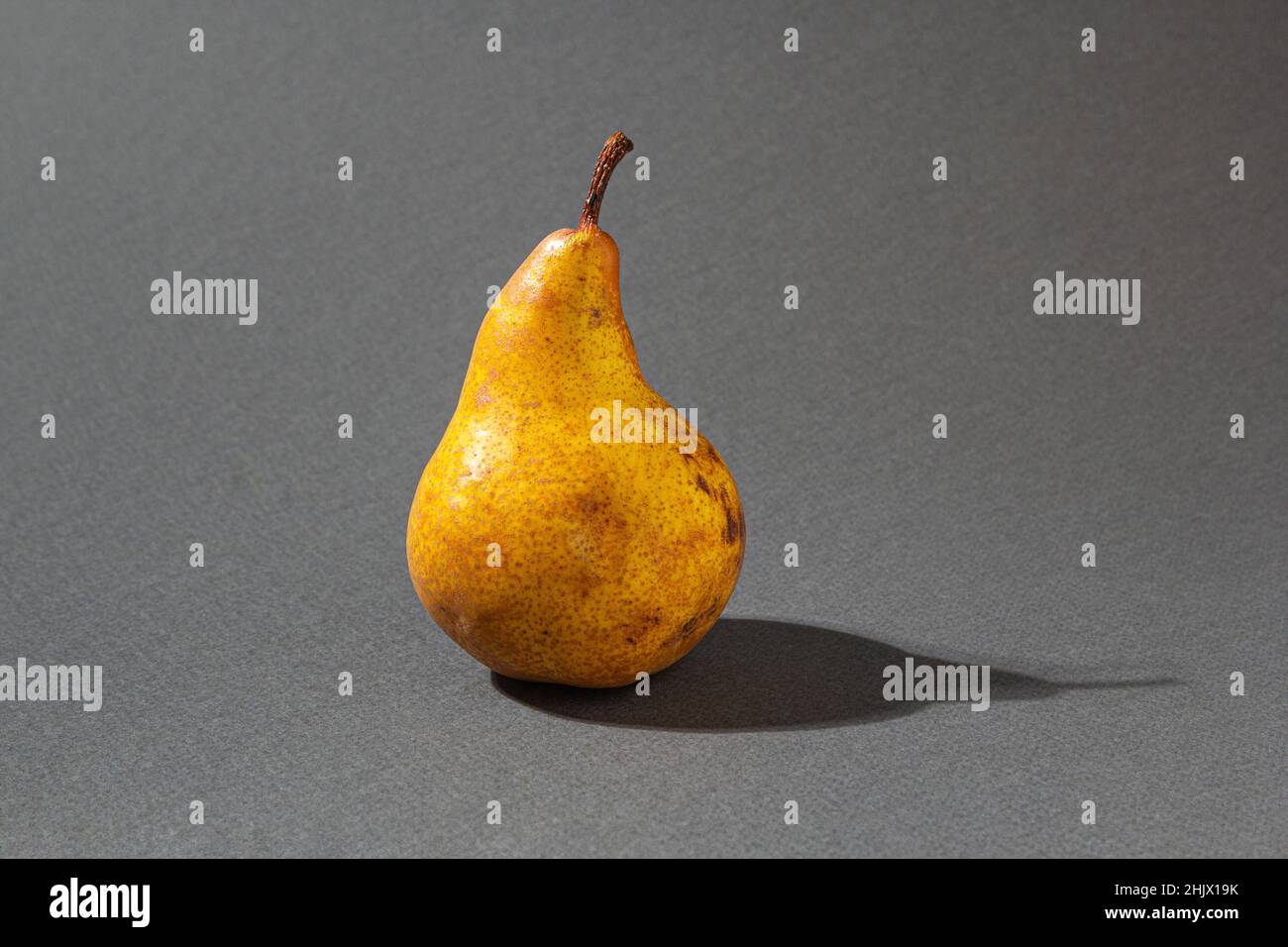 Minimalistic pear on grey background Stock Photo - Alamy