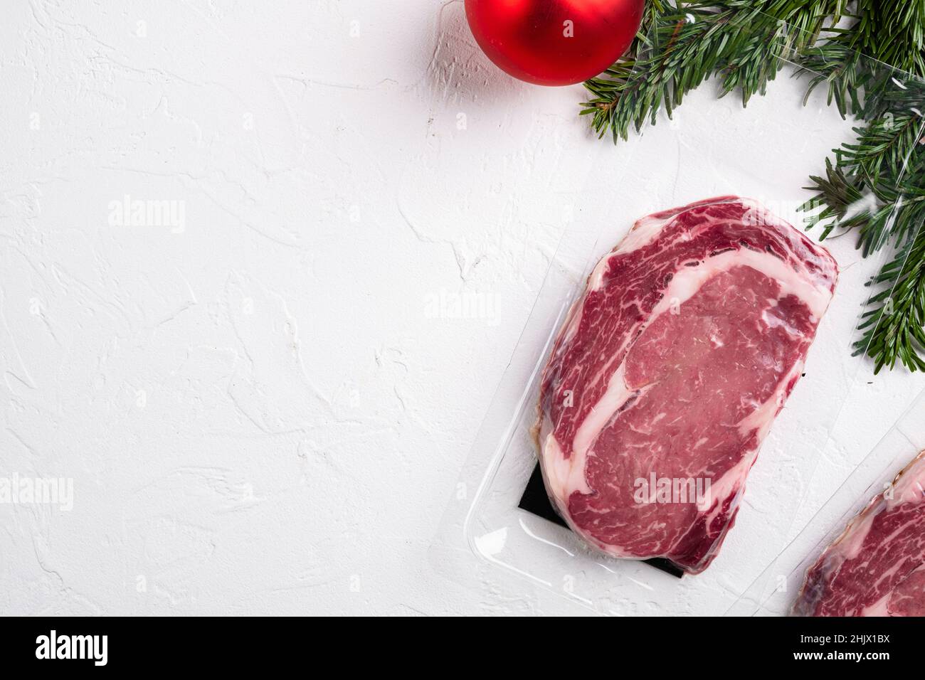 Rib-eye beef steak in plastic packing tray with Christmas tree ...
