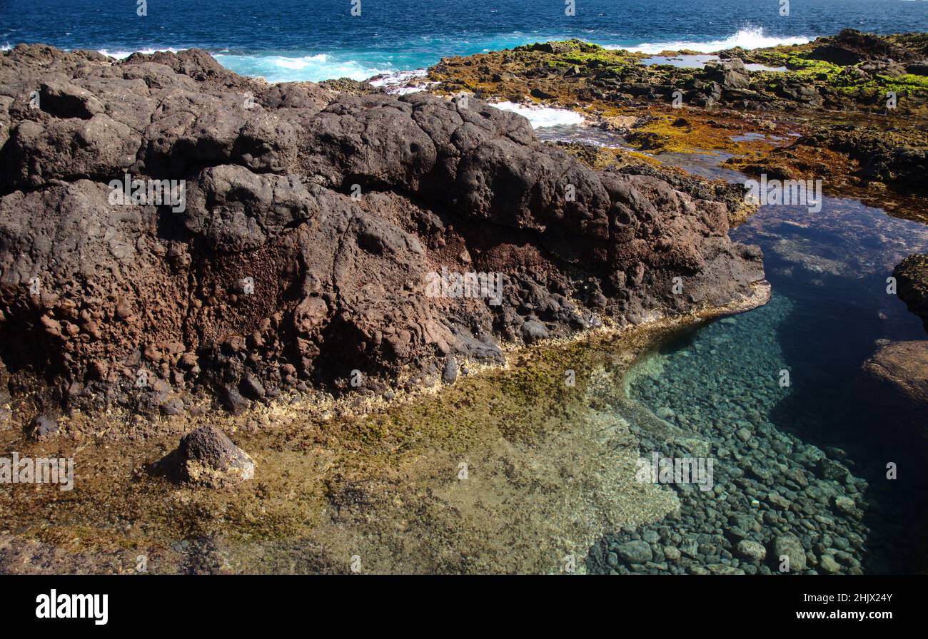Gran Canaria, calm rock pools under steep cliffs of the north coast are ...