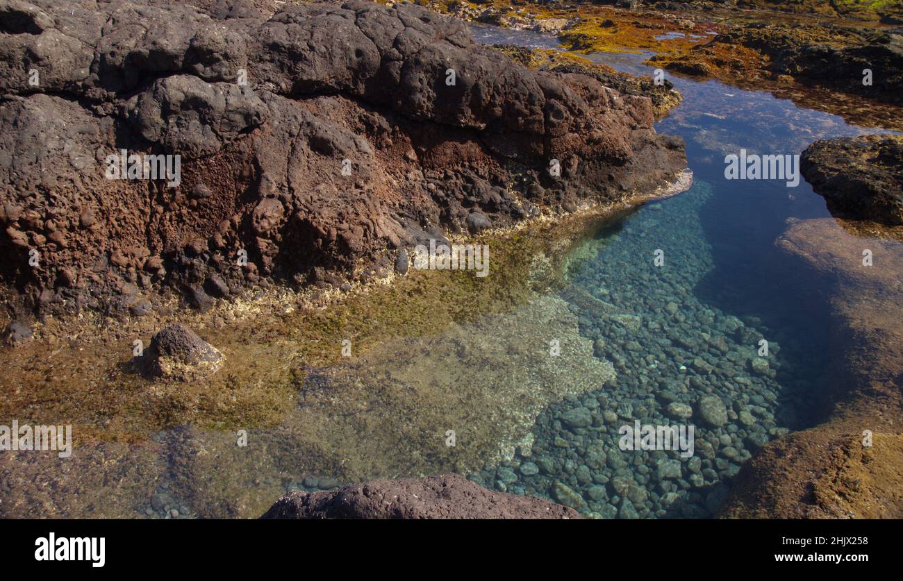 Gran Canaria, calm rock pools under steep cliffs of the north coast are ...