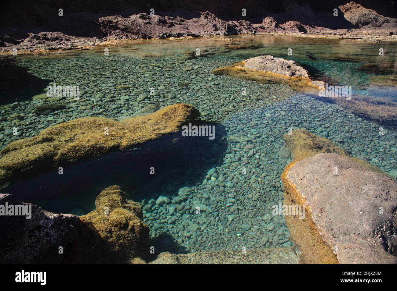 Gran Canaria, calm rock pools under steep cliffs of the north coast are ...