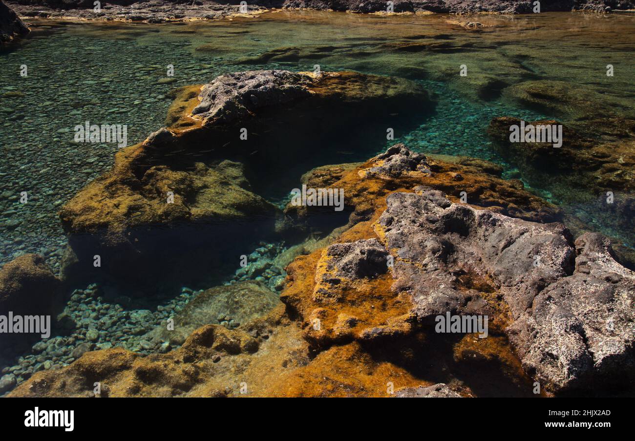 Gran Canaria, calm rock pools under steep cliffs of the north coast are ...