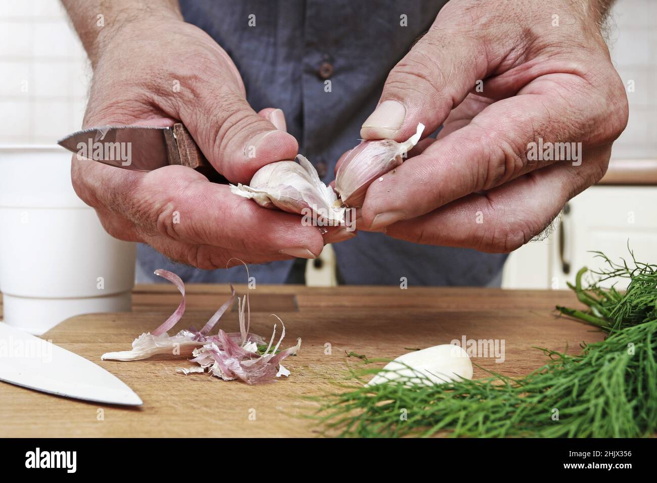 Man peels garlic in the kitchen. Cooking time Stock Photo - Alamy