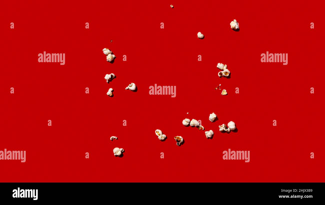 Popcorn on red background Stock Photo - Alamy