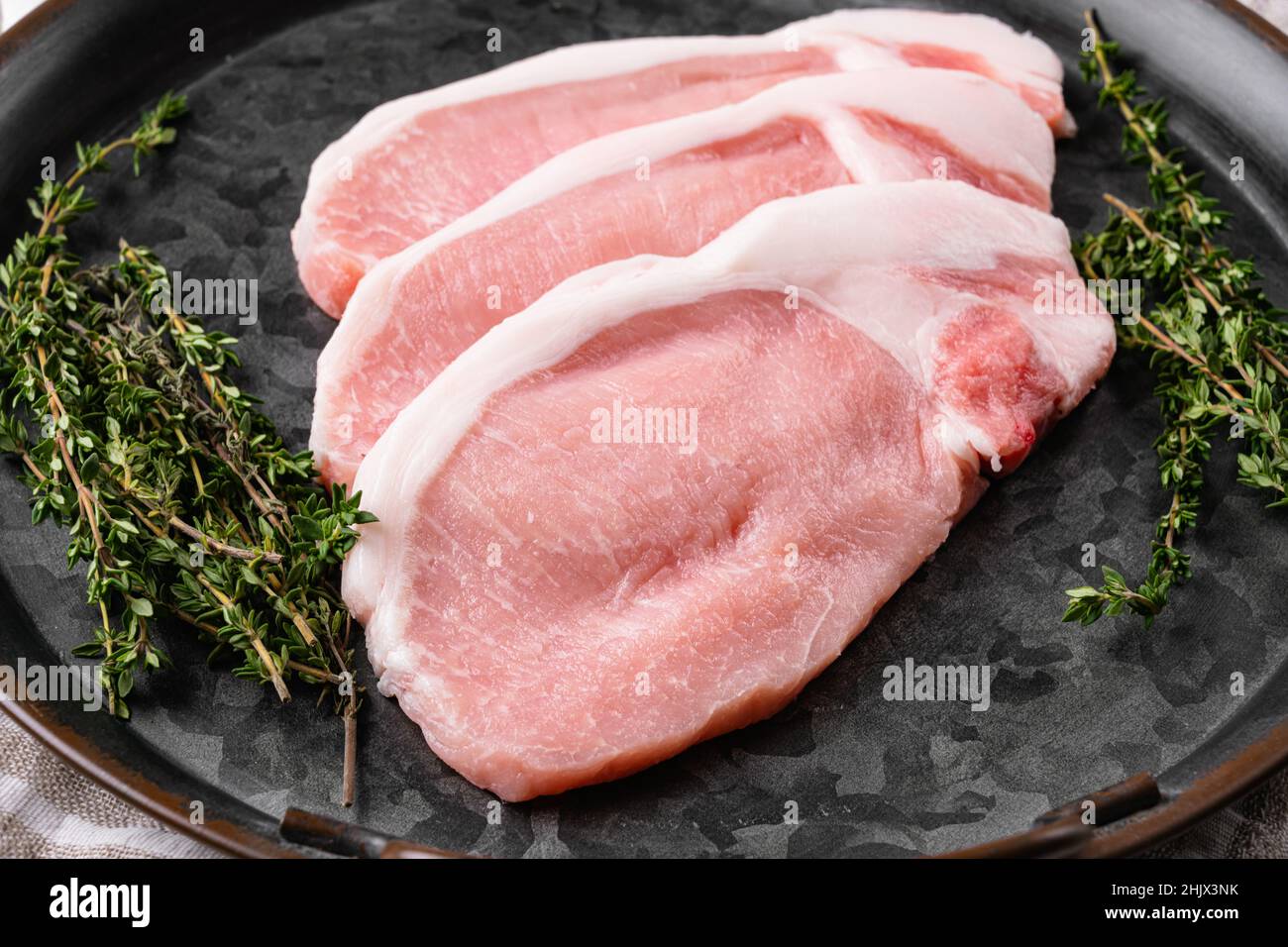 Raw organic meat. Pork steaks, fillets for grilling set, on white stone ...