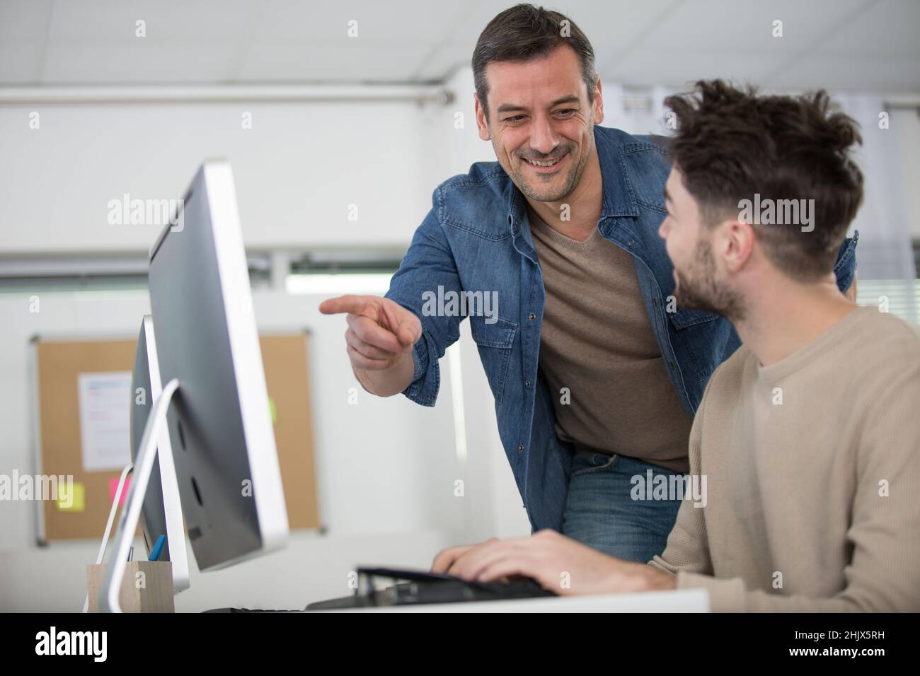 teacher helping student using computer Stock Photo - Alamy