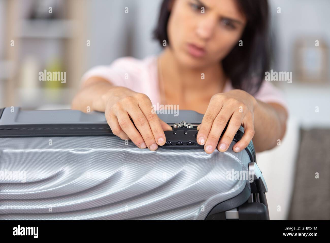 woman packing for vacation trying to close full suitcase Stock Photo ...