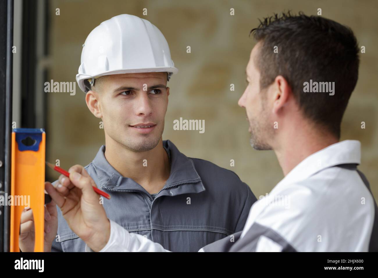 two builders with spirit level Stock Photo - Alamy