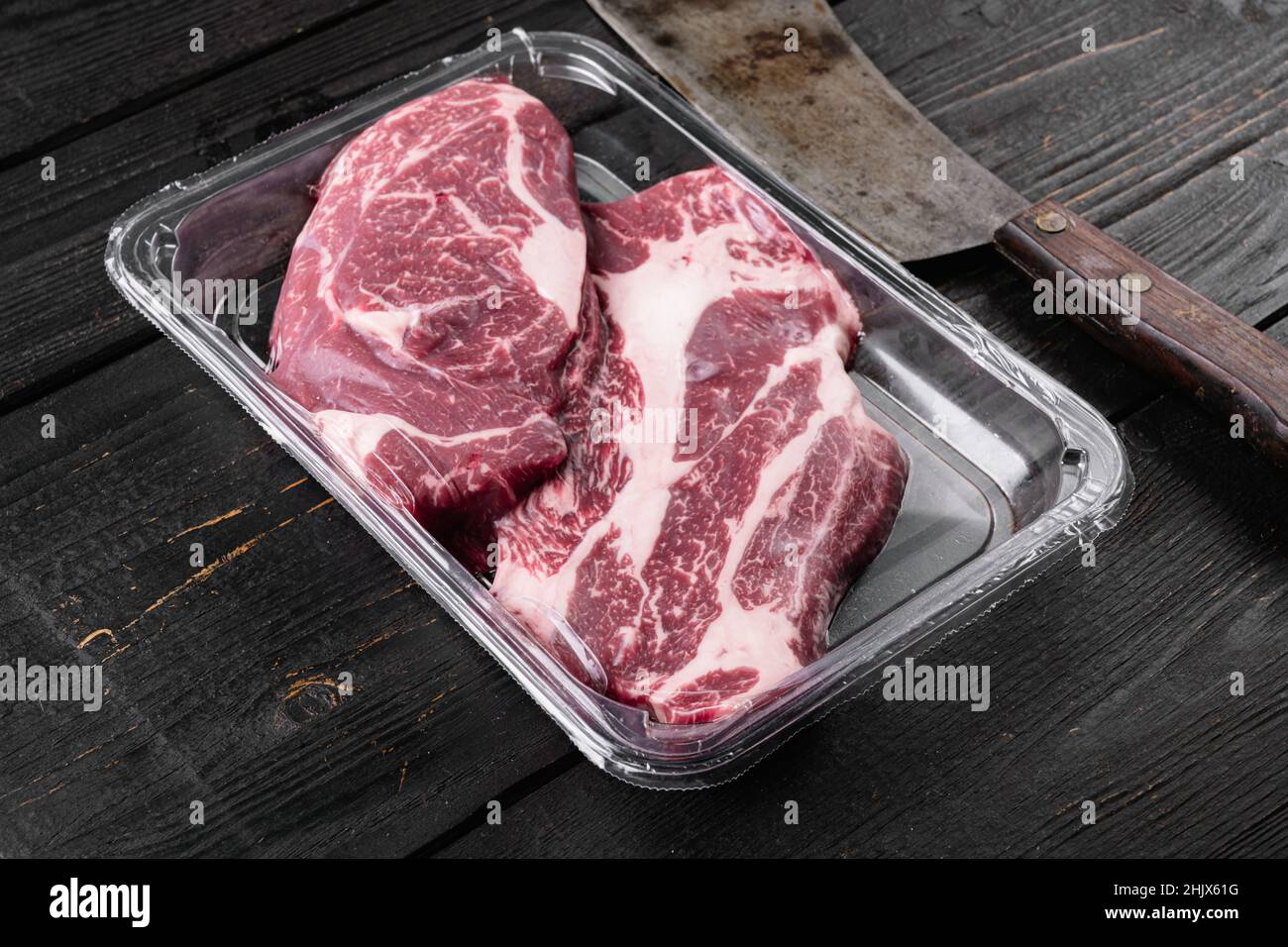 Meat in a package set, on black wooden table background, with copy ...