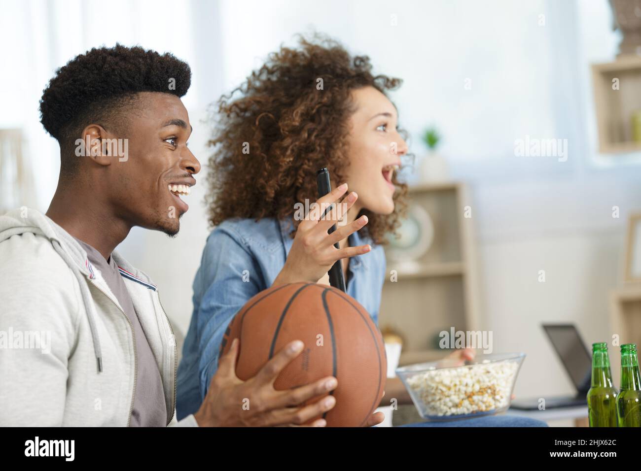young couple watching basketball match at home Stock Photo - Alamy