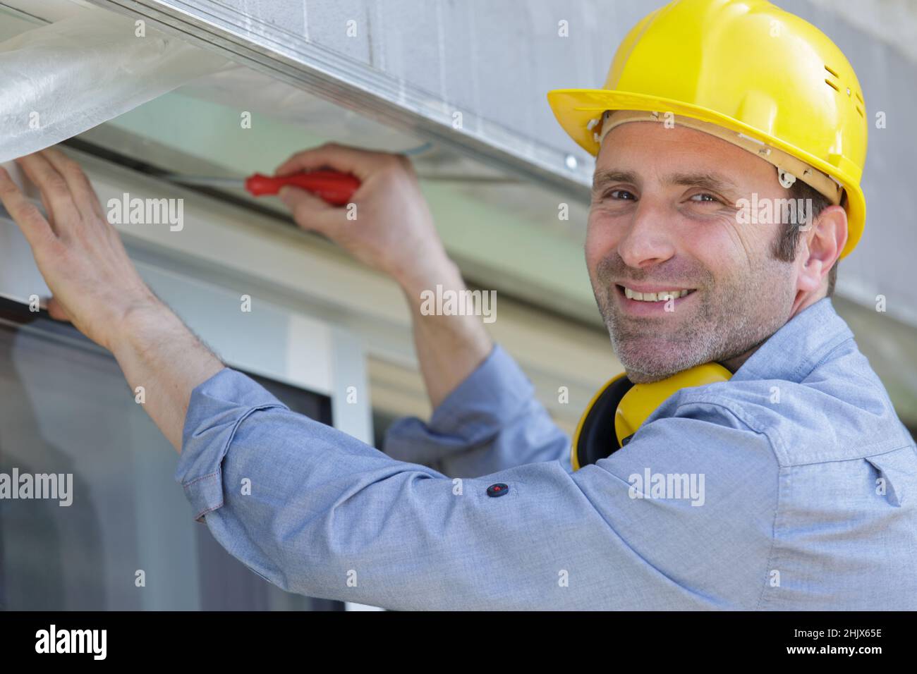 man installing roller shutter on window Stock Photo - Alamy
