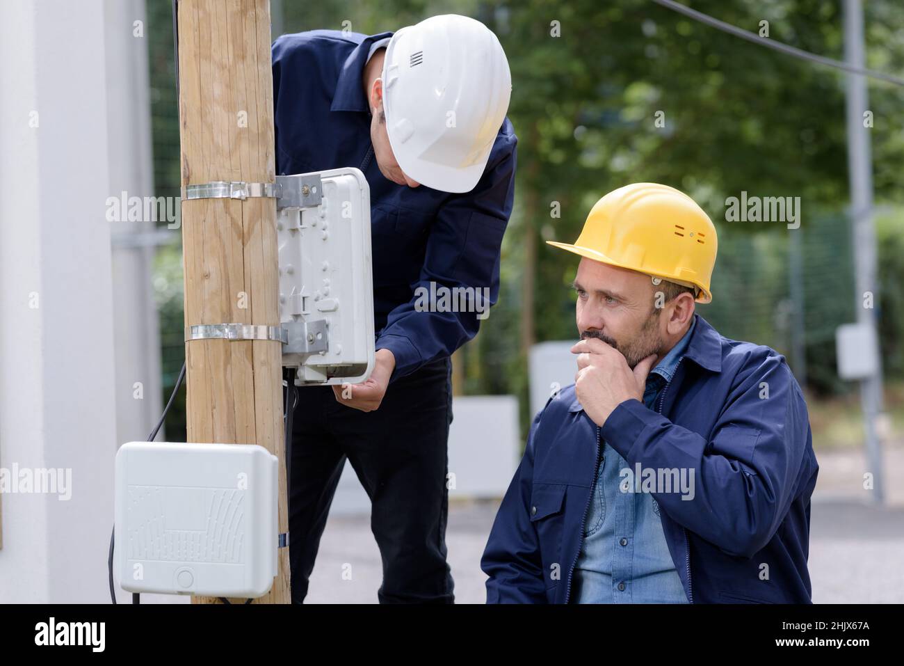 electrical workers putting announcement screen in a post Stock Photo ...