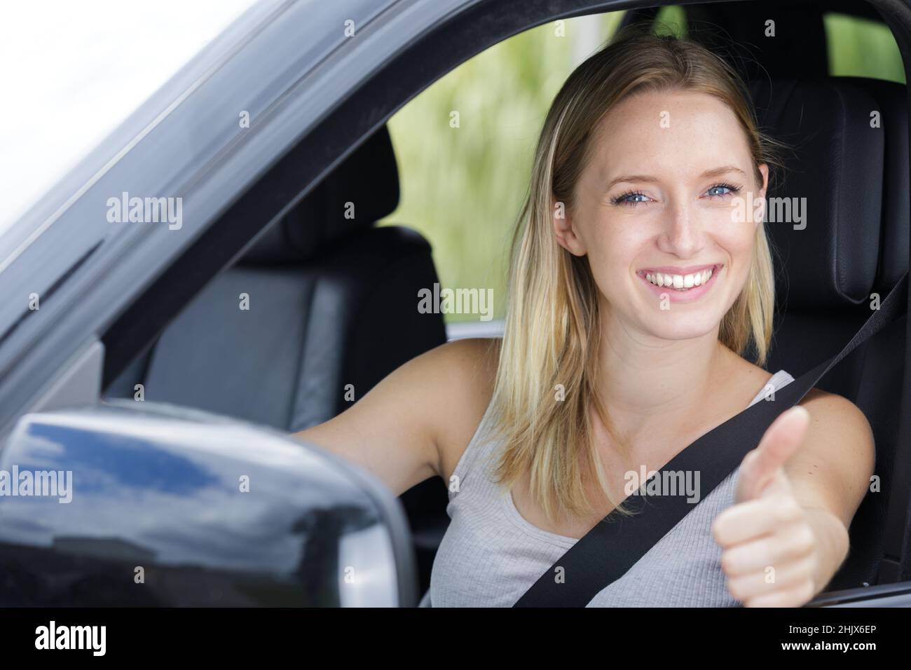 female driver holding thumbs up Stock Photo - Alamy