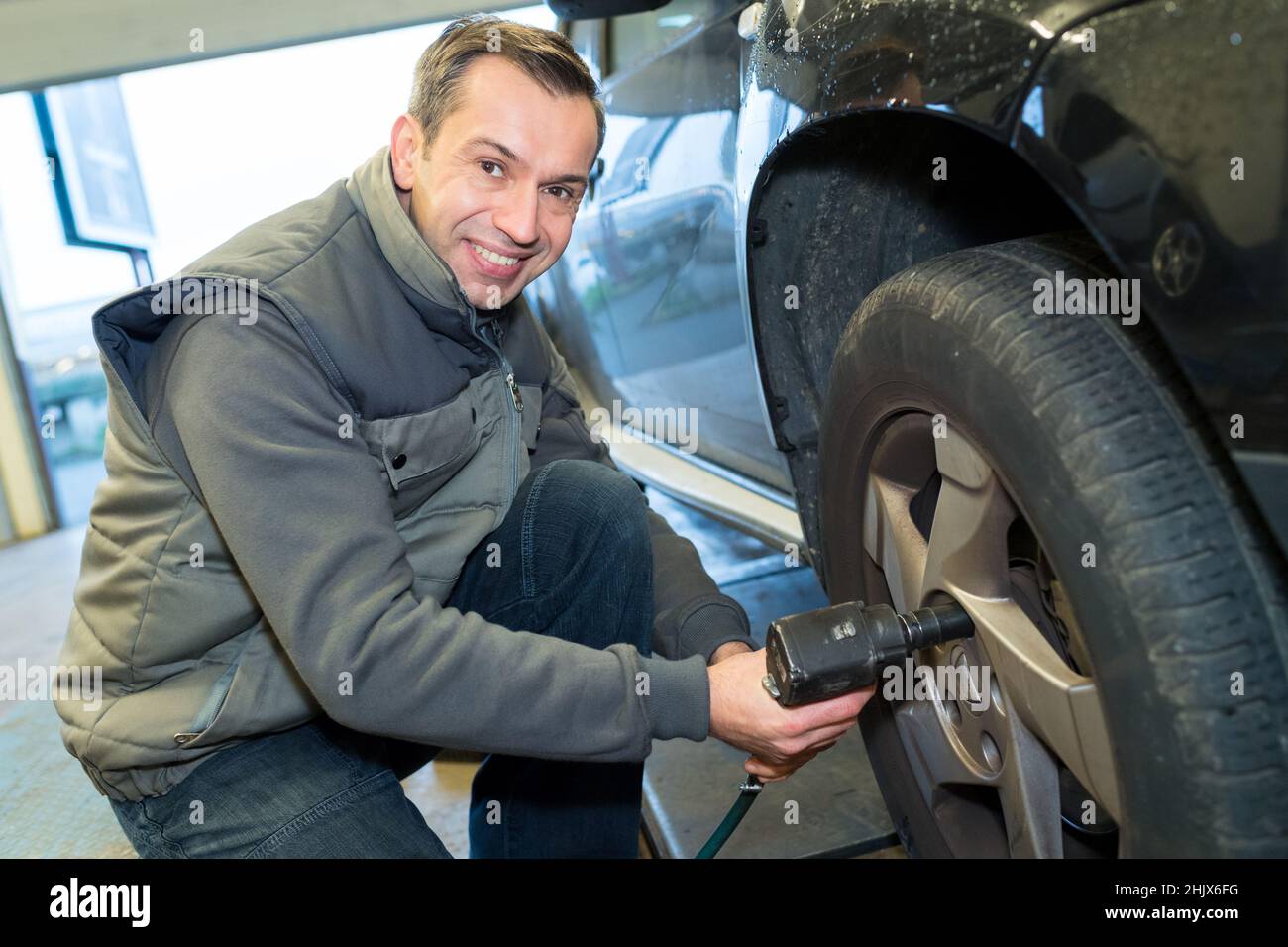 happy mechanic in tyre store warehouse Stock Photo - Alamy