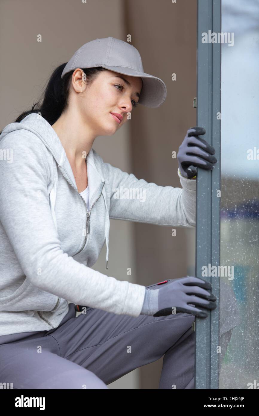 young woman mounting the window Stock Photo - Alamy