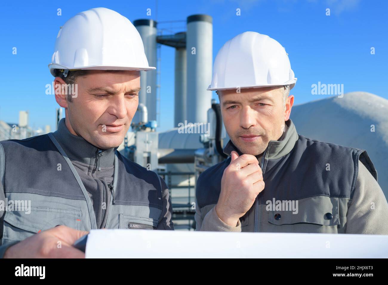 men at the factory in helmets metallurgy Stock Photo - Alamy