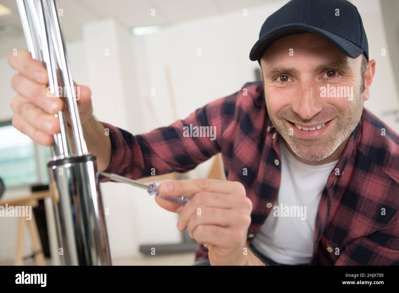 happy man uses the allen key screws aluminium chair Stock Photo - Alamy