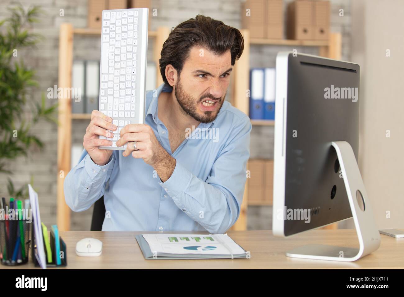 unhappy employee screaming mad in front of the monitor Stock Photo - Alamy