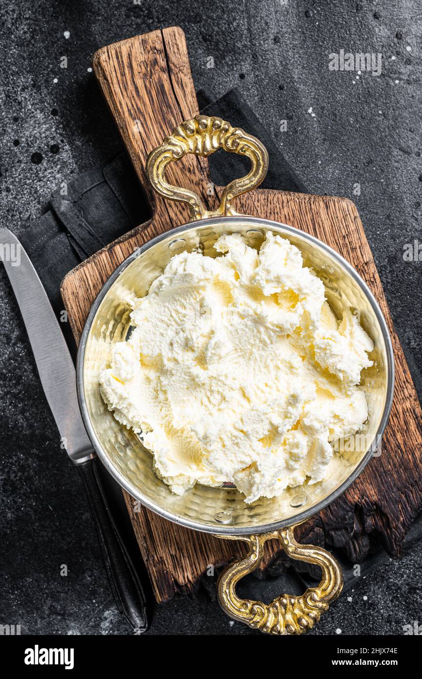 Kaymak Clotted cream, butter cream in a rustic pan. Black background ...