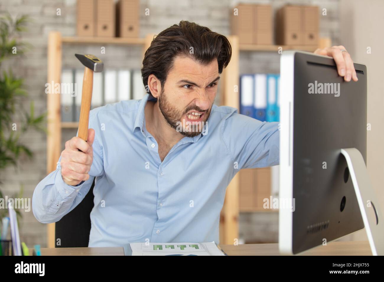 angry businessman holding hammer over laptop in his office Stock Photo ...