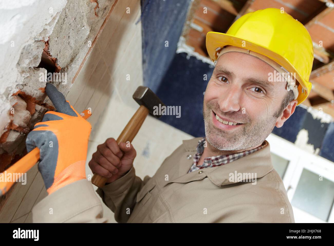 construction worker demolishing hole at a wall Stock Photo - Alamy