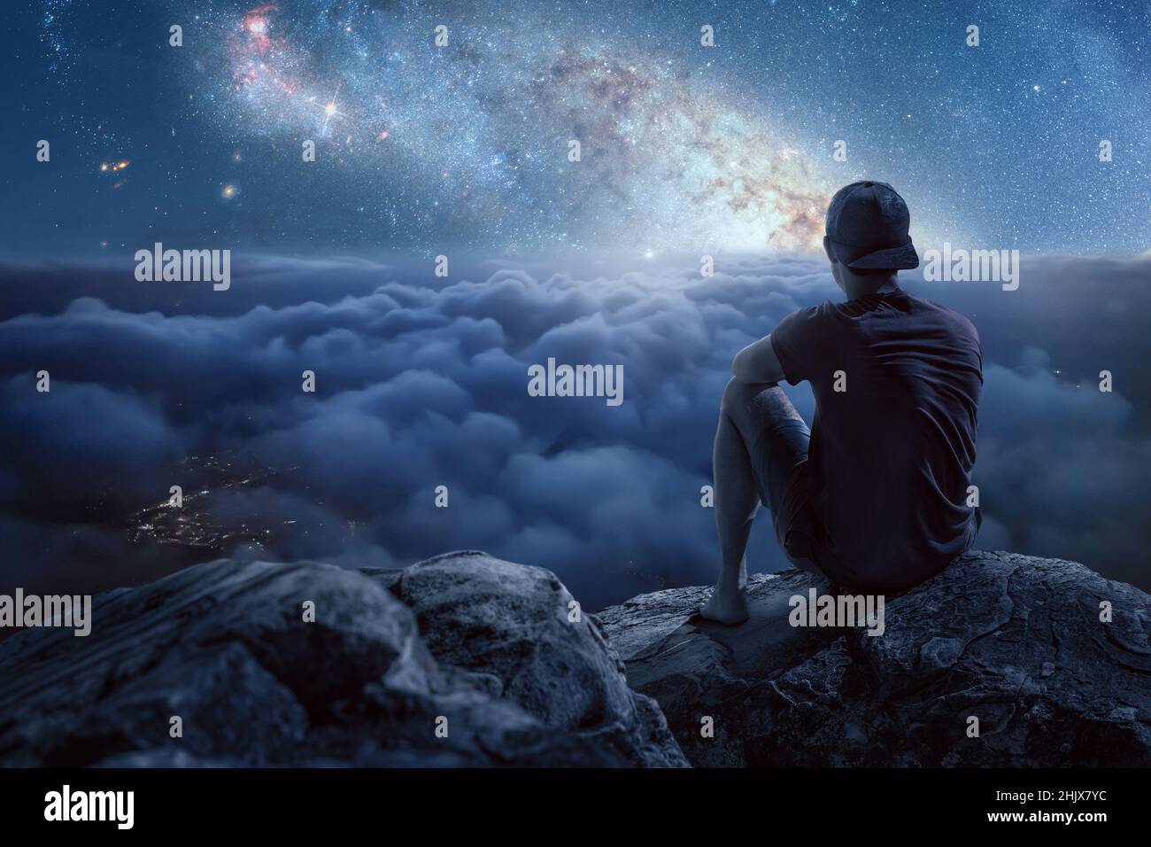 Man on a mountain looking at a beautiful starry night sky Stock Photo ...
