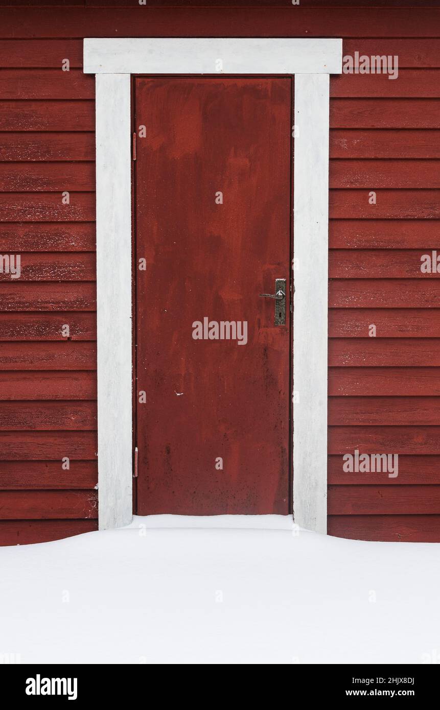Snow in front of red door Stock Photo - Alamy
