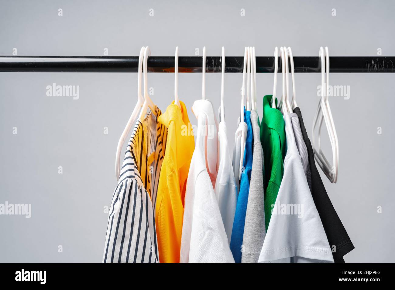Clothes hang on clothing rack over white background Stock Photo - Alamy