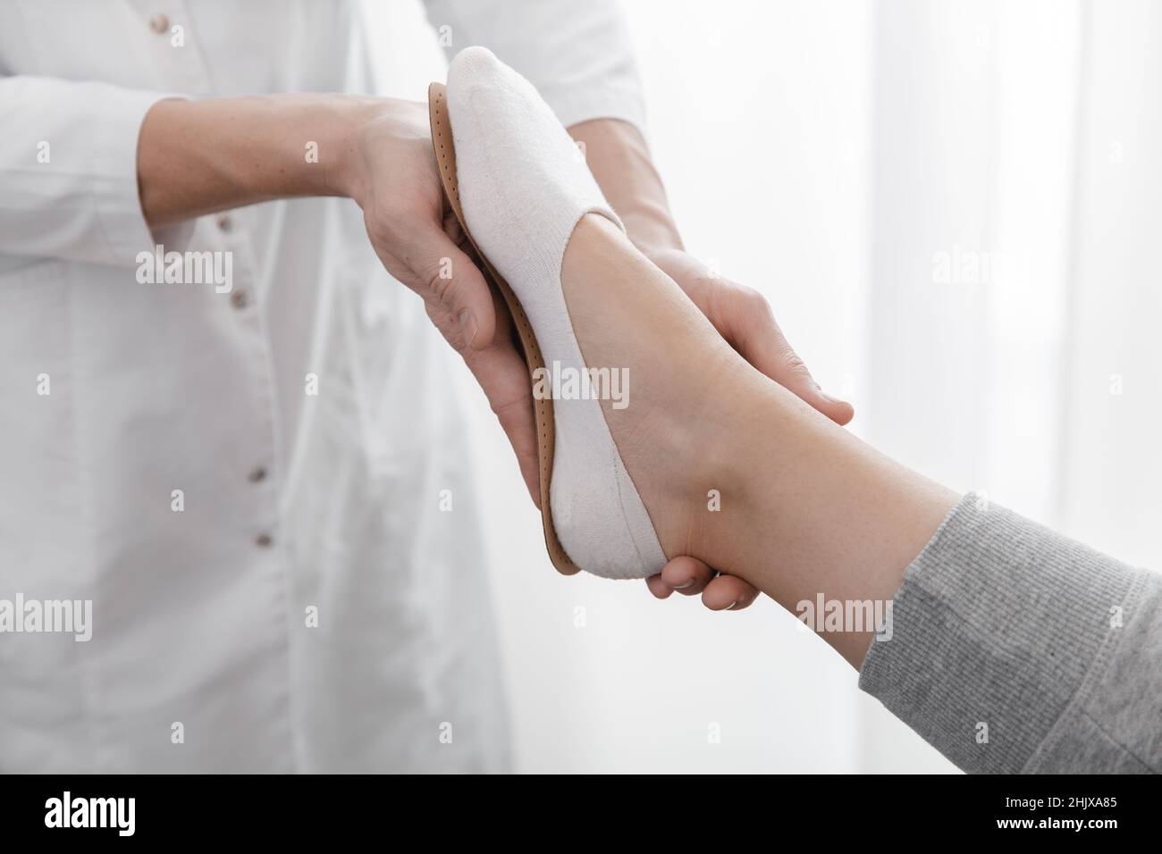 Doctor hands hold an orthopedic insole. Orthopedist tests the medical ...
