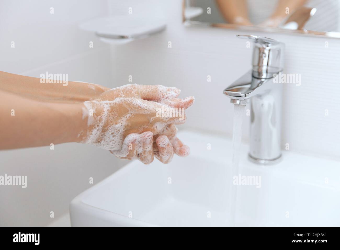 Washing hands under the flowing water tap. Hygiene concept hand detail ...