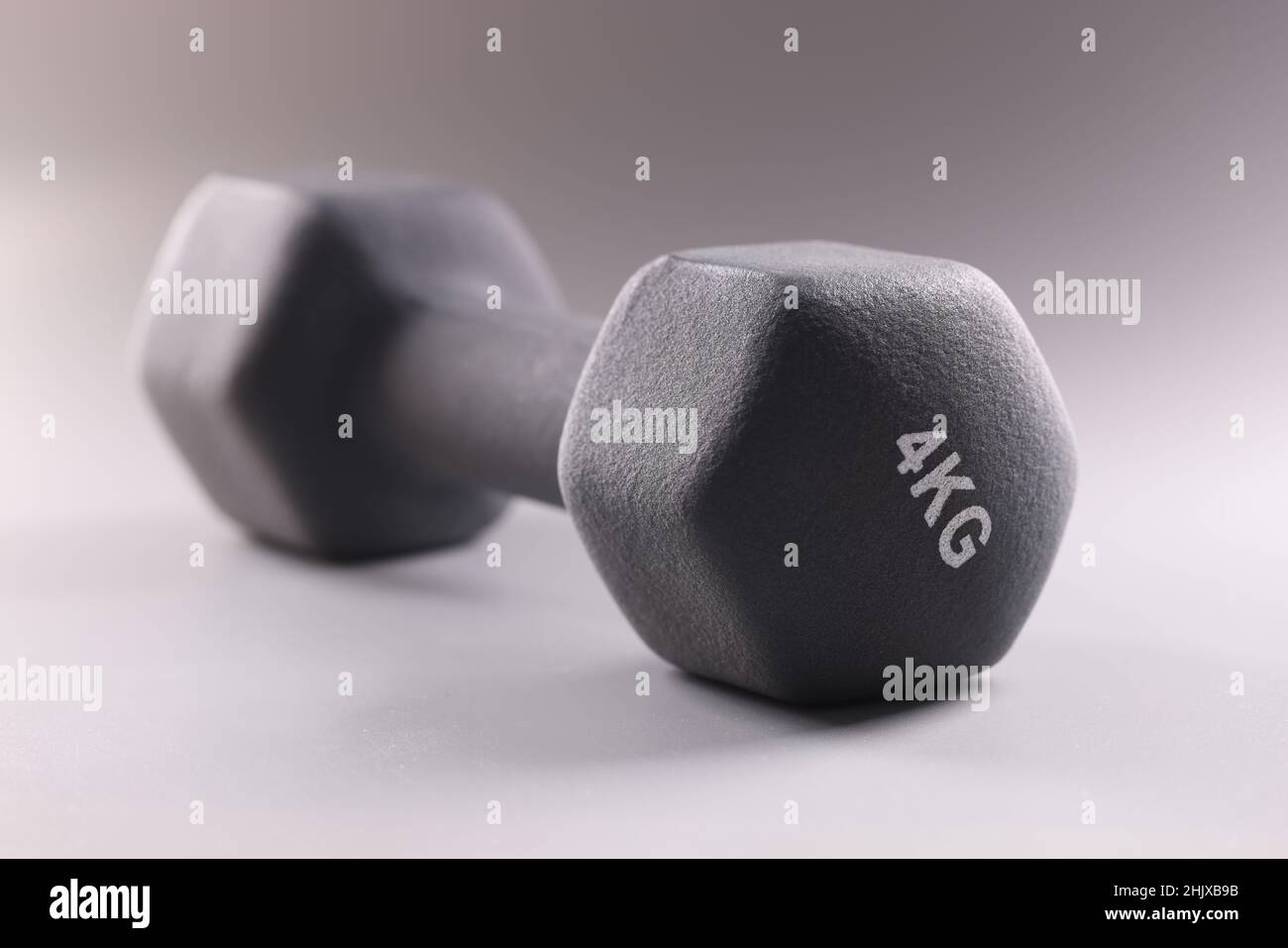 Black sports dumbbell for bodybuilding on gray background closeup Stock ...