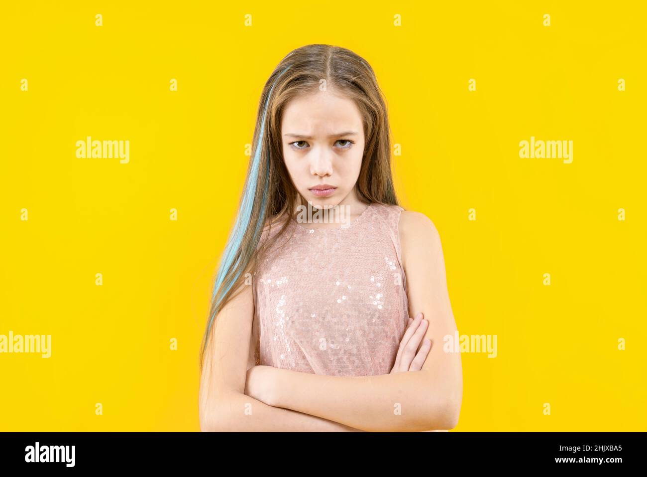 The girl is offended. Displeased teenager on a yellow background ...