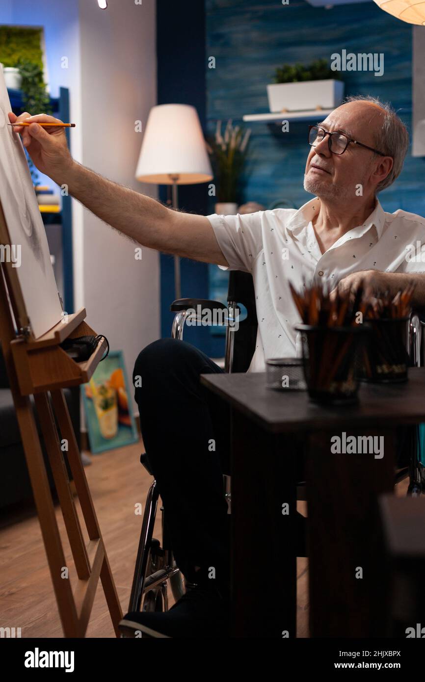 Elderly citizen drawing still nature on easel in home art studio for ...