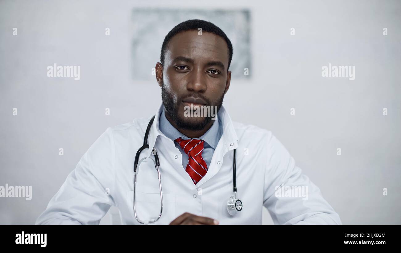 serious african american doctor with stethoscope looking at camera ...