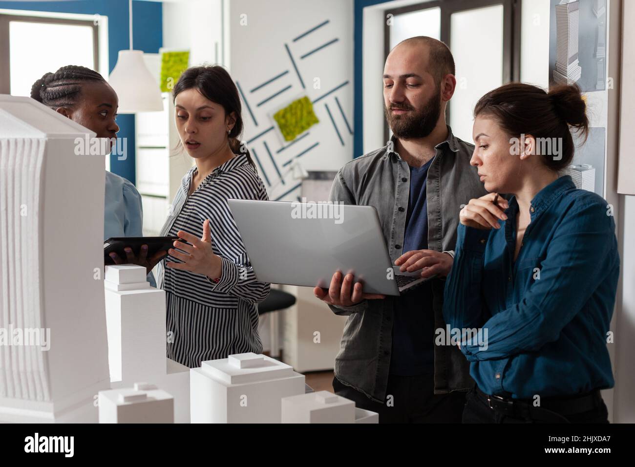Team of professional architects meeting at office analyzing blueprints ...