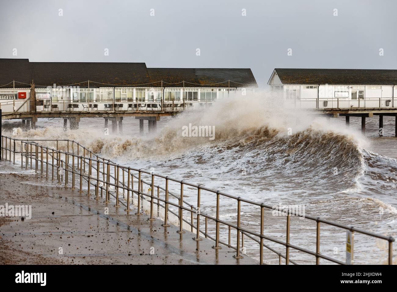 Crashing breaking waves at high tide pounding the beach promenade at ...