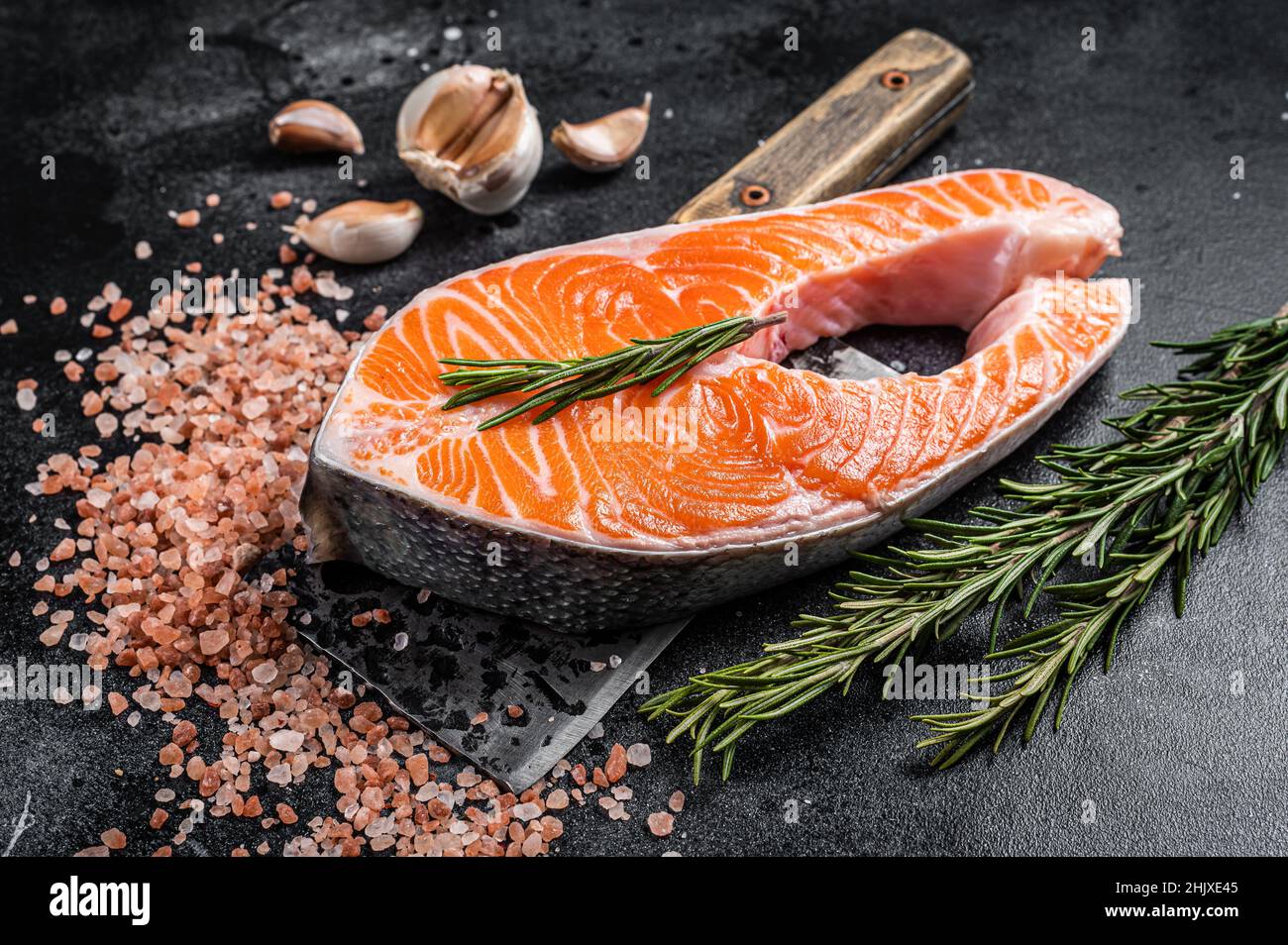 Raw Salmon trout Fish Steak on butcher table with meat cleaver. Black ...