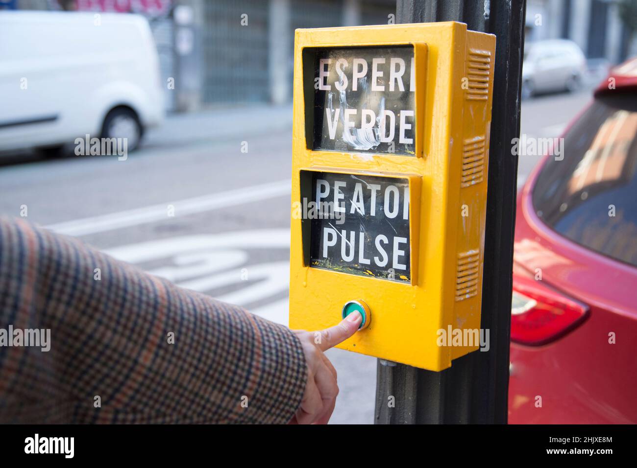 senior Caucasian woman's hand pressing the yellow traffic light button ...