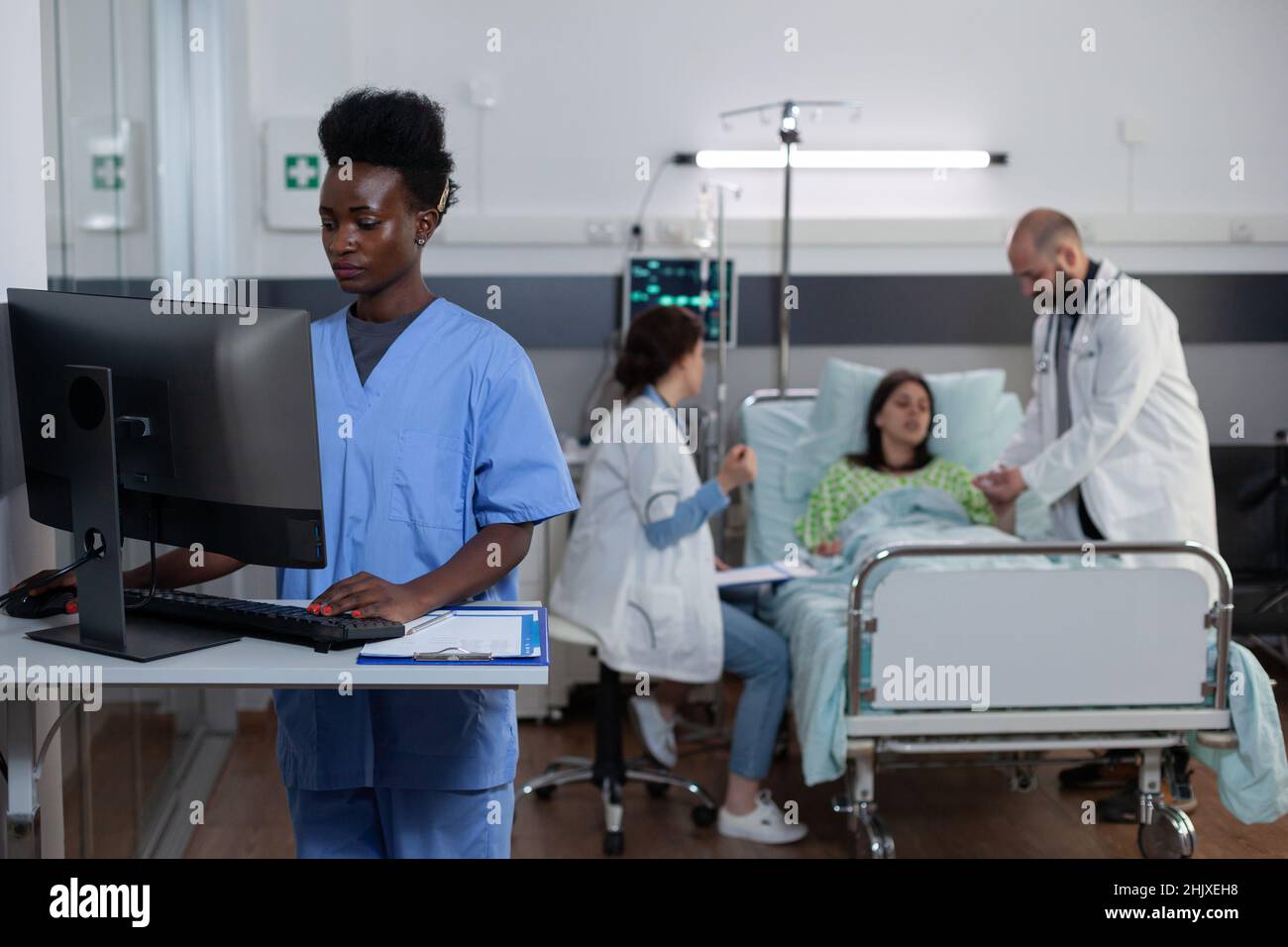 Nurse using personal computer to complete patient admission chart and ...