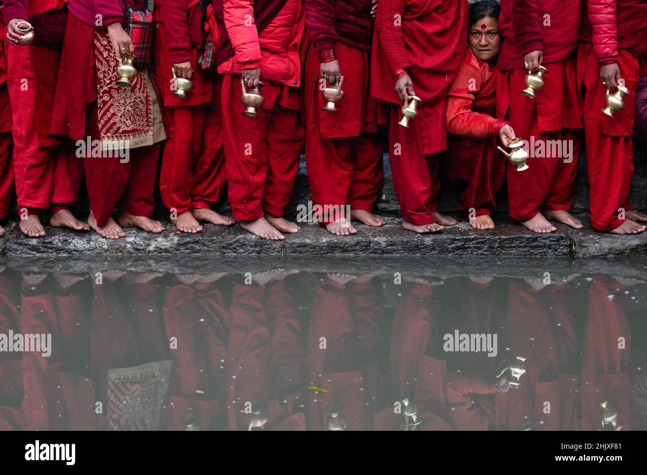 Devotees holding water pots fill water from the Bagmati River, which is ...