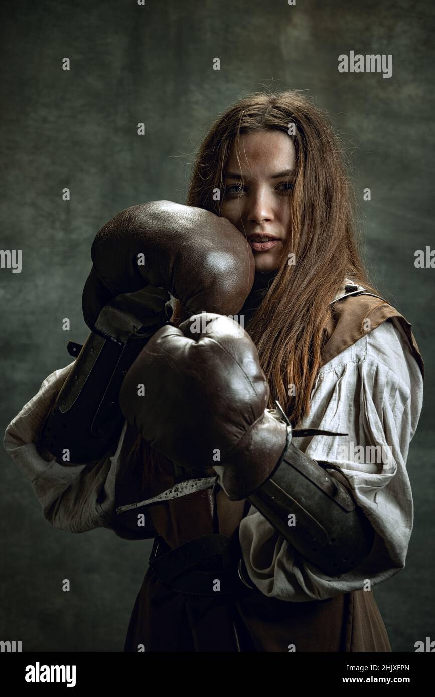 Portrait of brave girl, medieval warrior or knight with dirty wounded ...