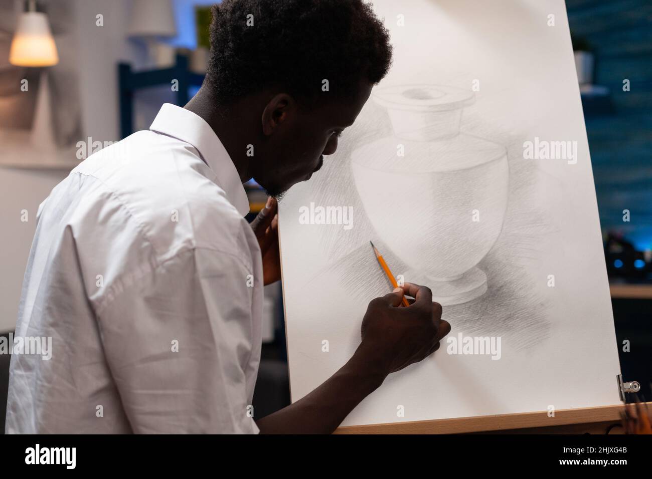 Young artist drawing vase making shadows using professional graphic ...