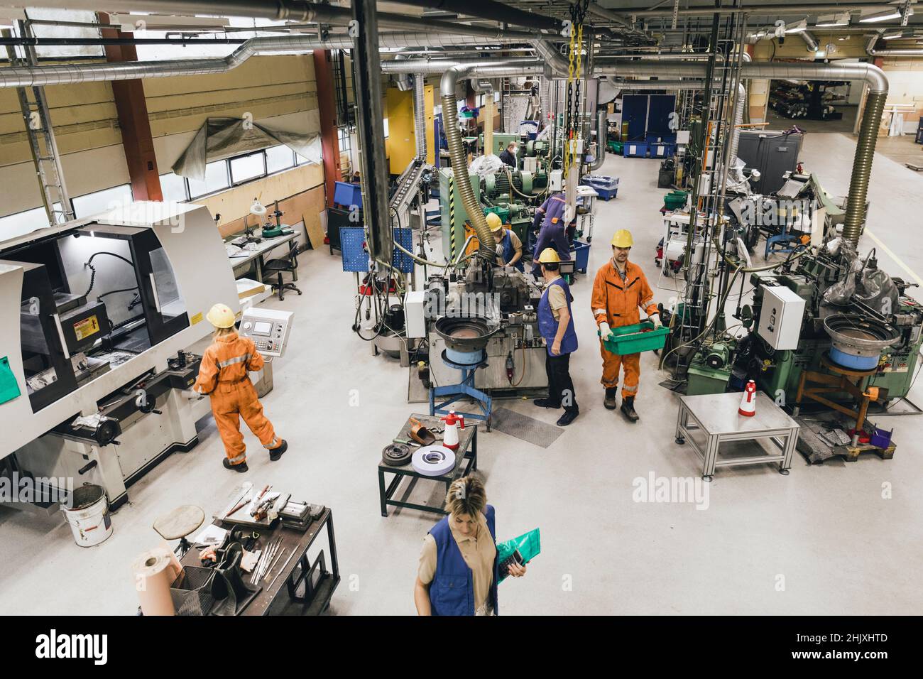 Female and male workers wearing uniform working in factory warehouse ...
