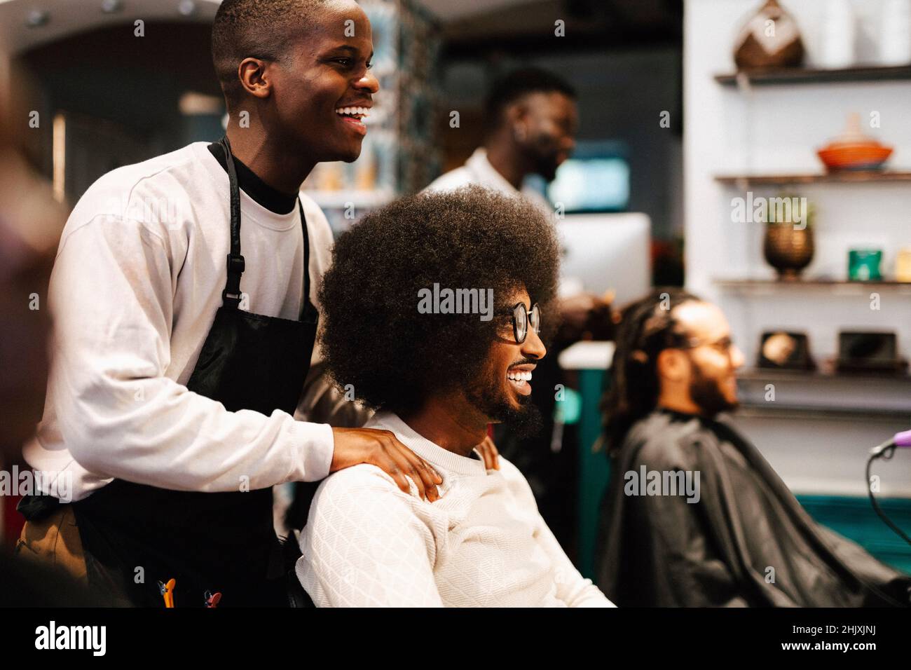Happy male hairdresser talking with customer in barber shop Stock Photo ...