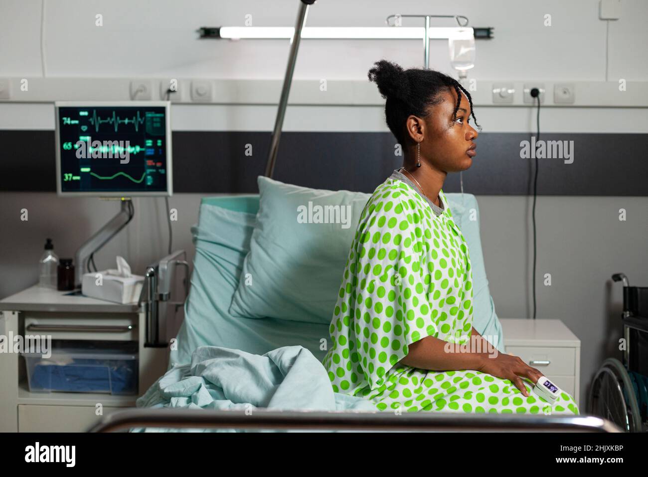 Young patient standing on bed recovering after disease surgery during ...
