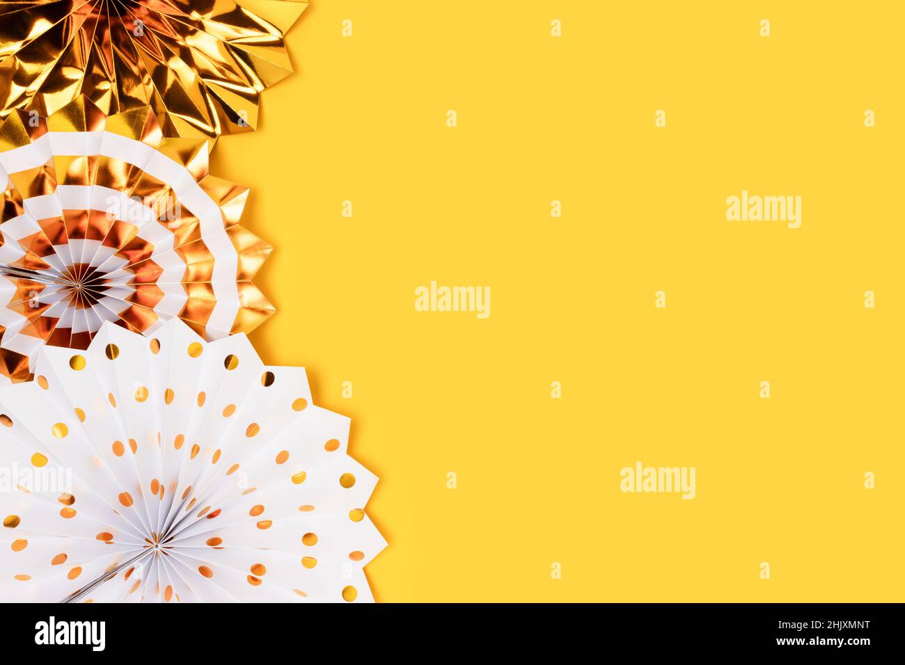 Frame made of golden paper fans on a yellow background with copy space ...
