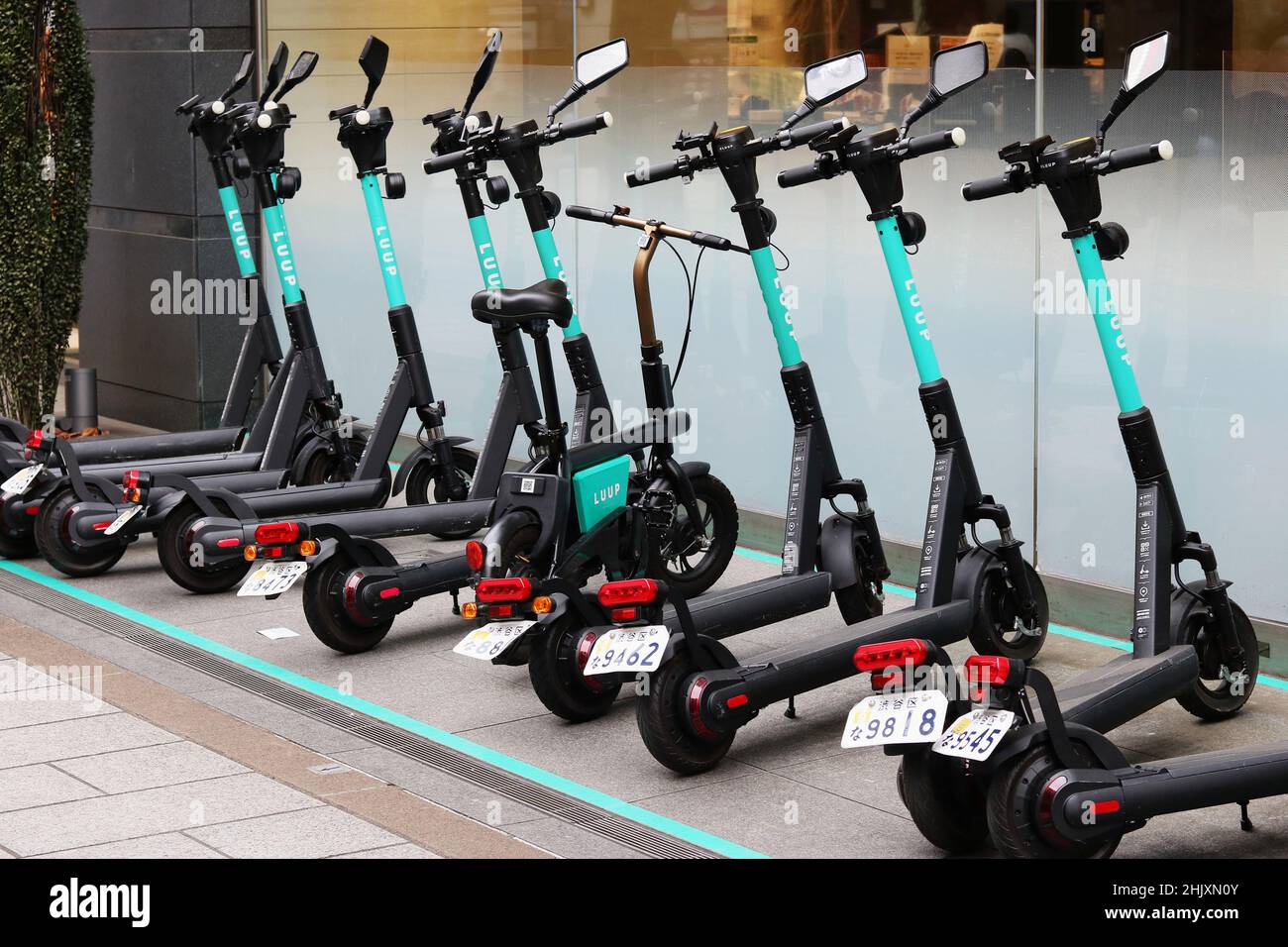 Row of Luup rental e-scooters and bicycles outside a bakery cafe in ...