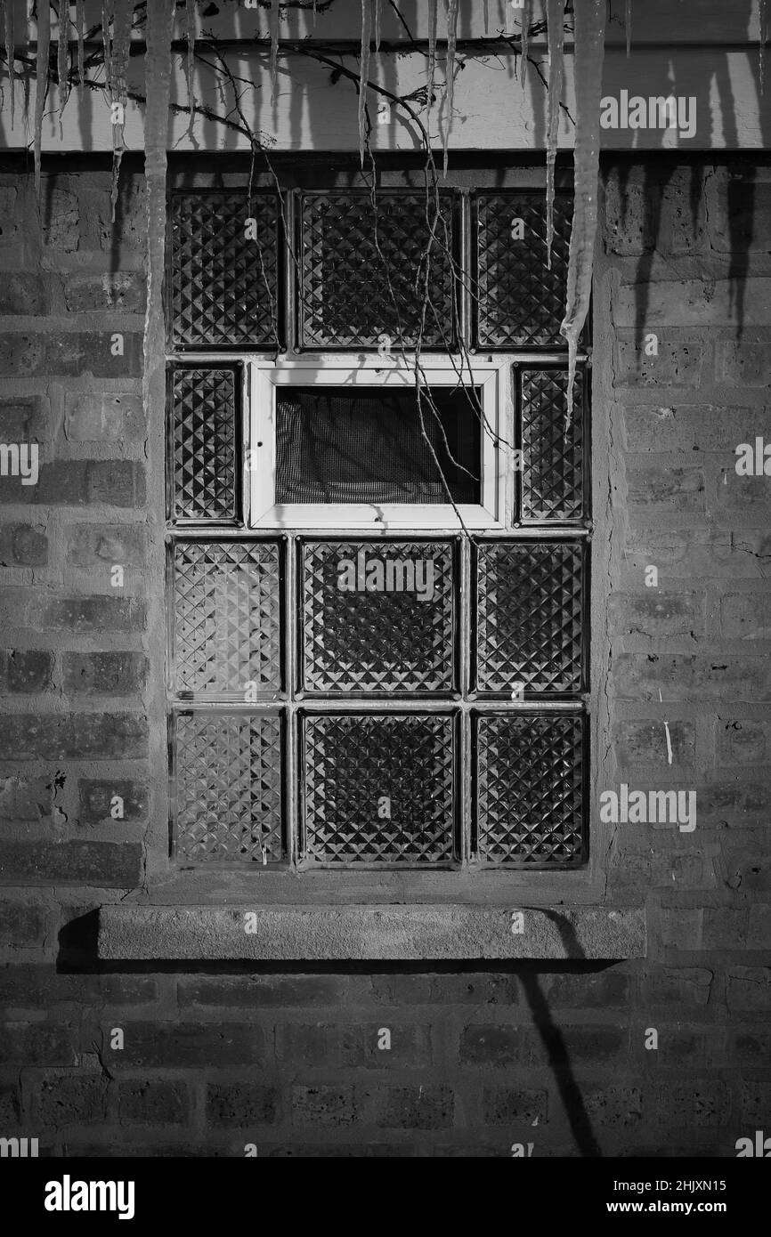 Old glass block window with icicles in the inner city alley Stock Photo ...